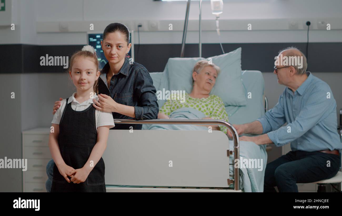 Portrait of mother and child sitting in hospital ward at family visit ...