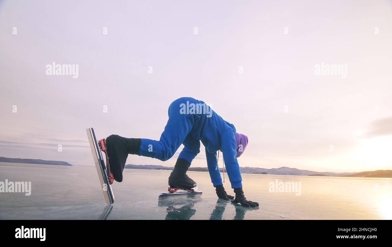 The child train on ice speed skating. The athlete at the start, in a ...