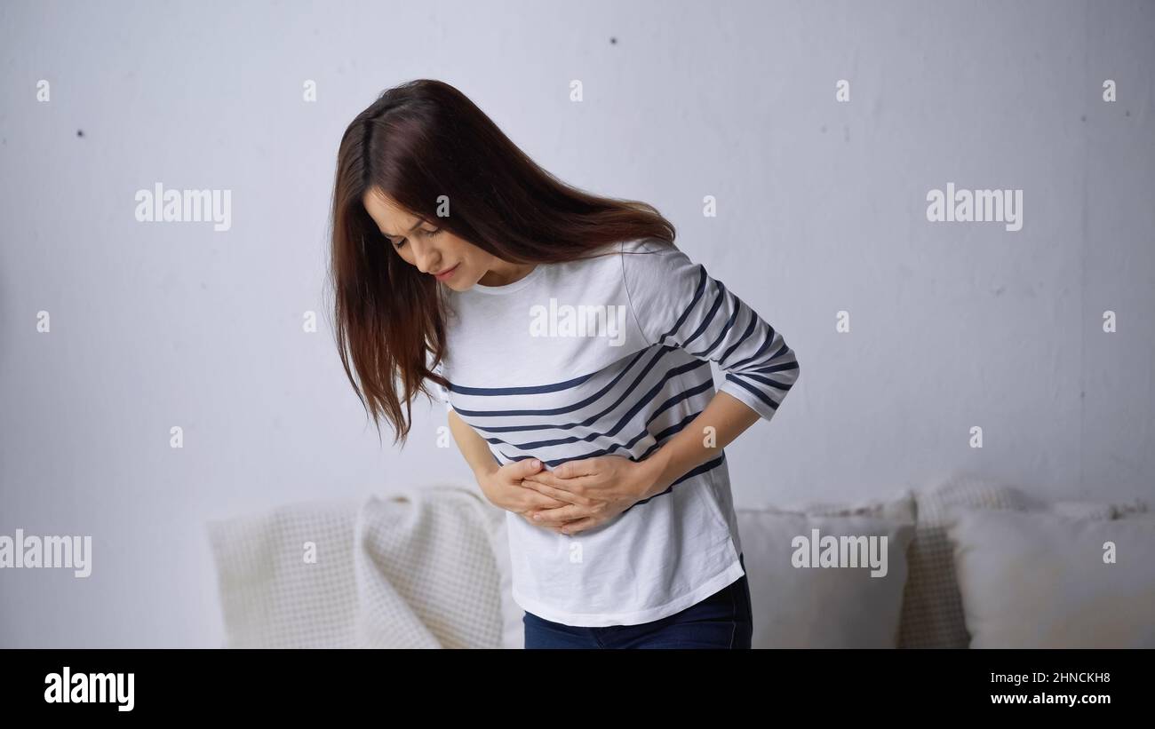 upset woman touching belly while suffering from stomach pain Stock ...