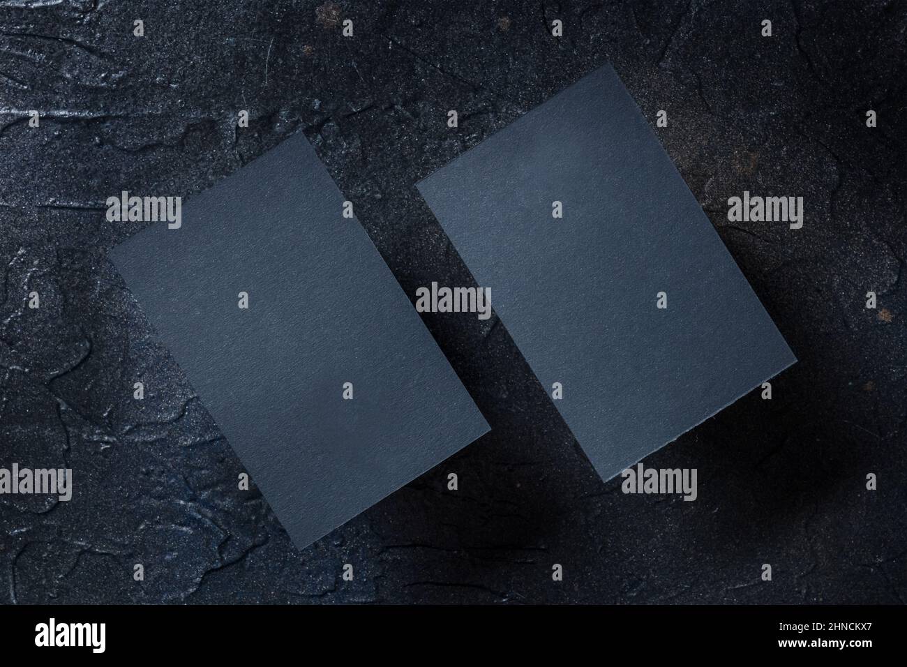 Black business card mock-up on a dark background, front and back, a ...