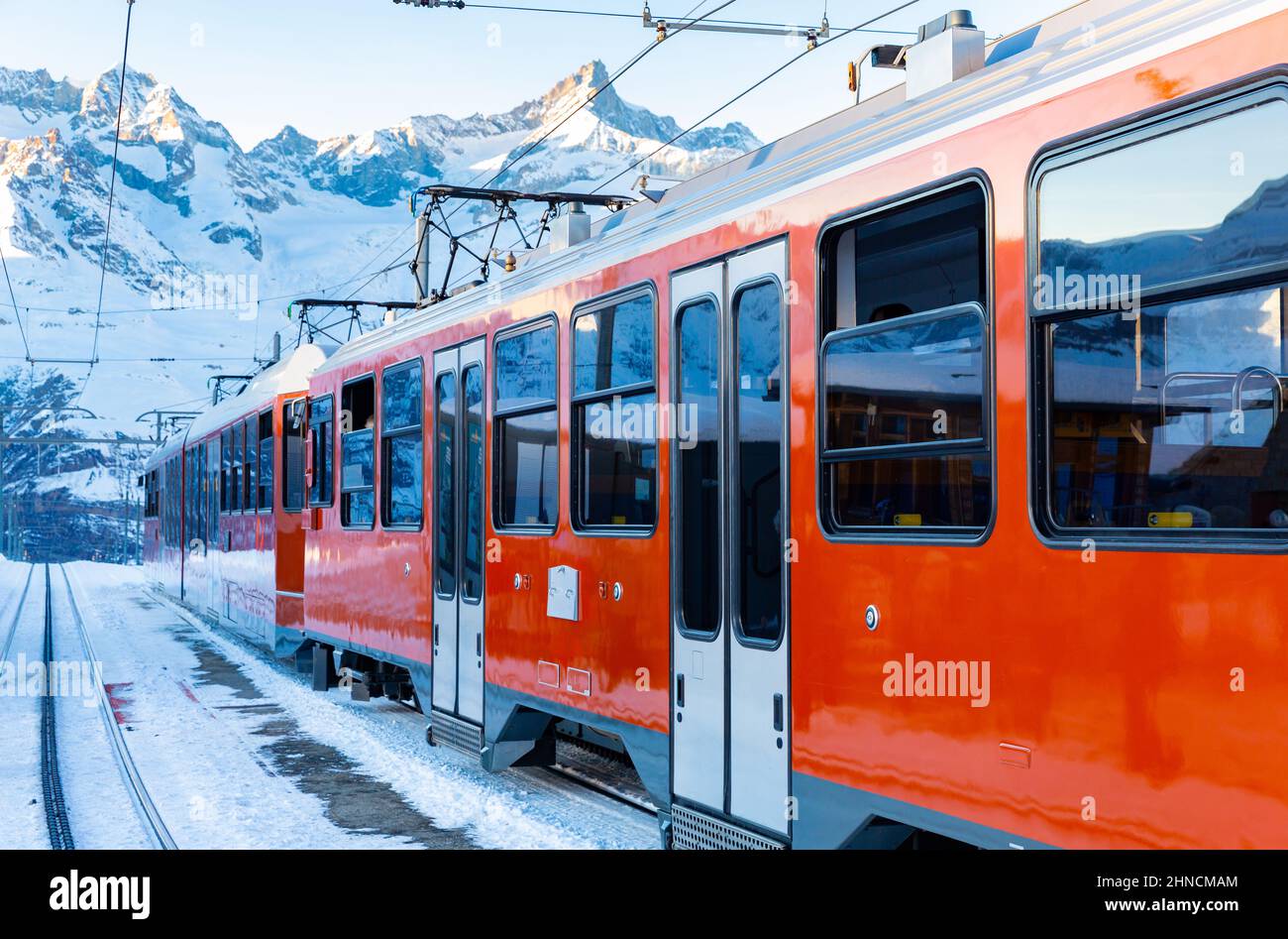 Red train running on rack railway through snowy Swiss Alps Stock Photo ...