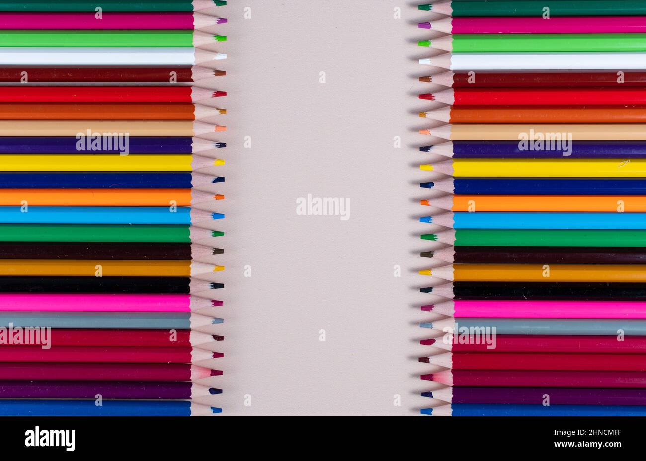 Closeup of a Plain background and pencils of different colors lined up ...
