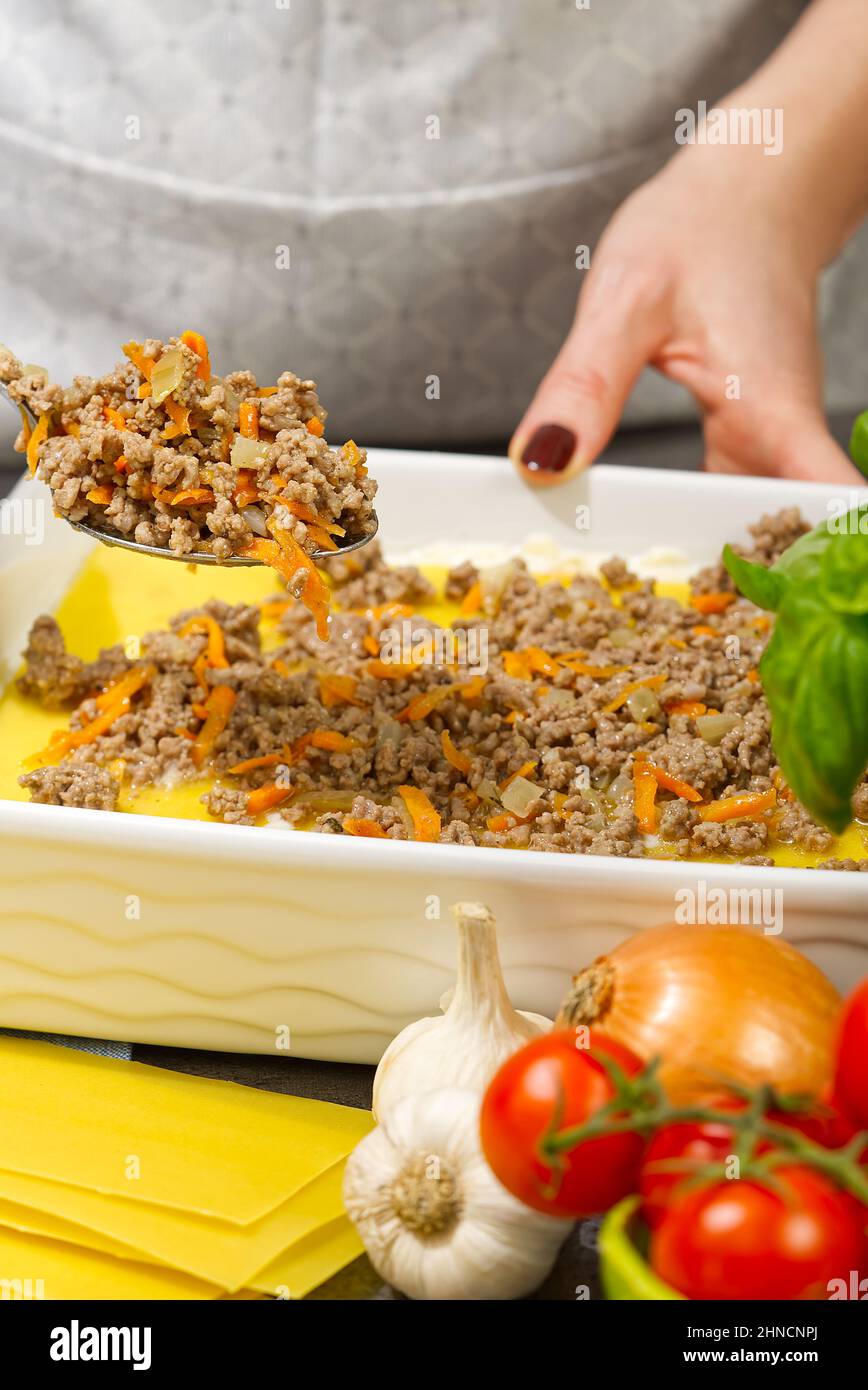 Woman preparing meat lasagna in kitchen. lasagna recipe - Italian food ...