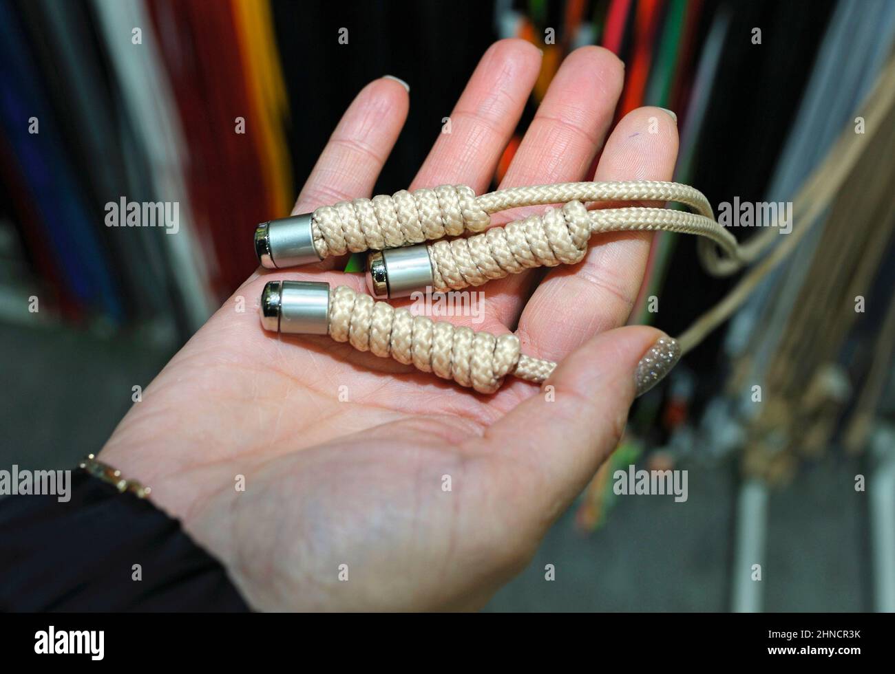 Woman hand holding fittings, drawstrings for hoods and boots. Closeup ...