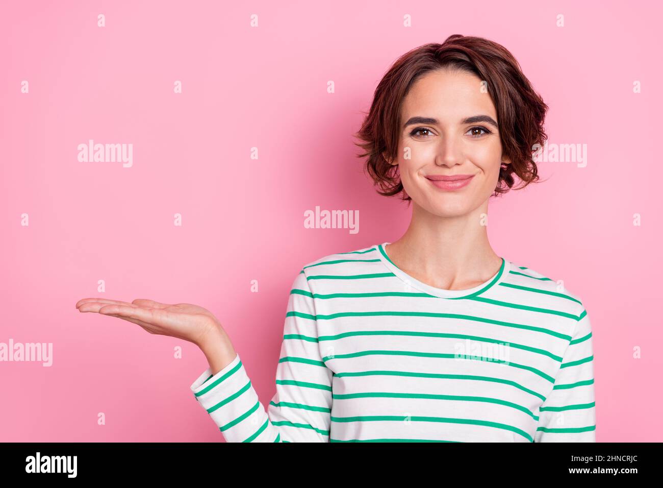 Portrait of attractive cheerful girl holding on palm copy blank space ...