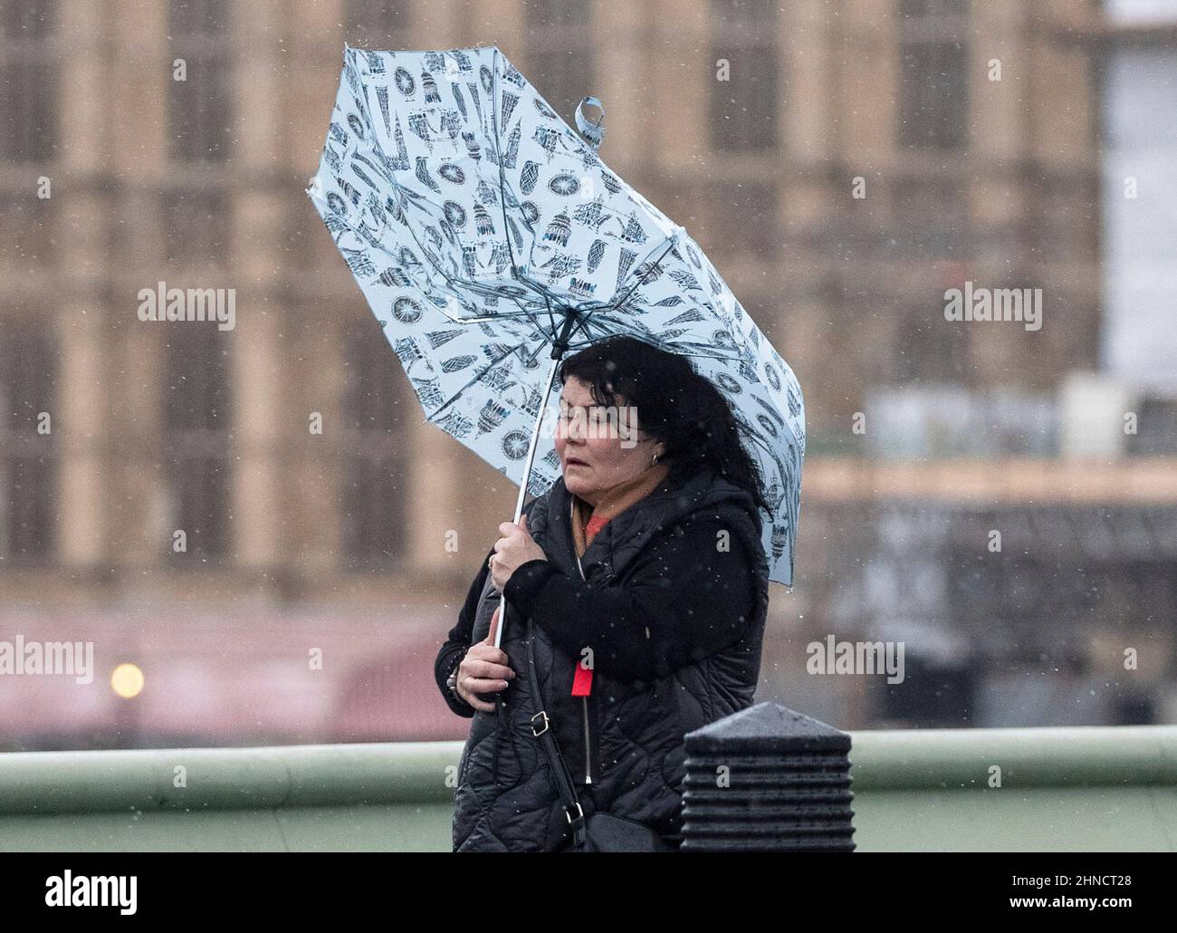 Women struggle with umbrellas during wet and windy weather in Central ...