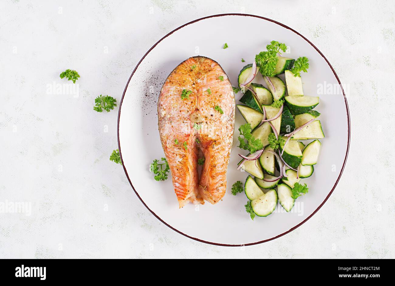 Baked salmon fish steak and fresh cucumber salad with red onions. Top ...