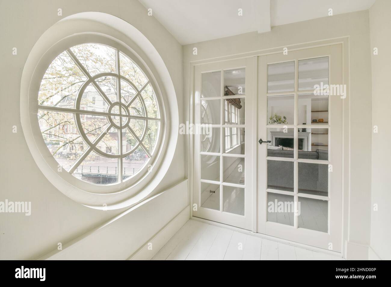 White wall with round window in light corridor of modern apartment with ...