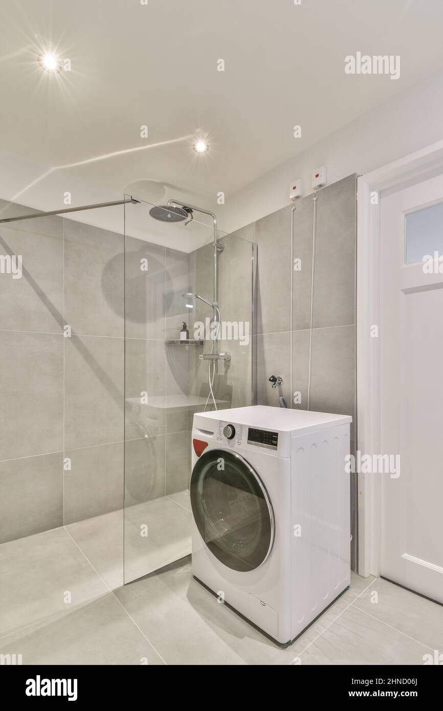 Interior of contemporary bathroom with white tiled wall and washing ...