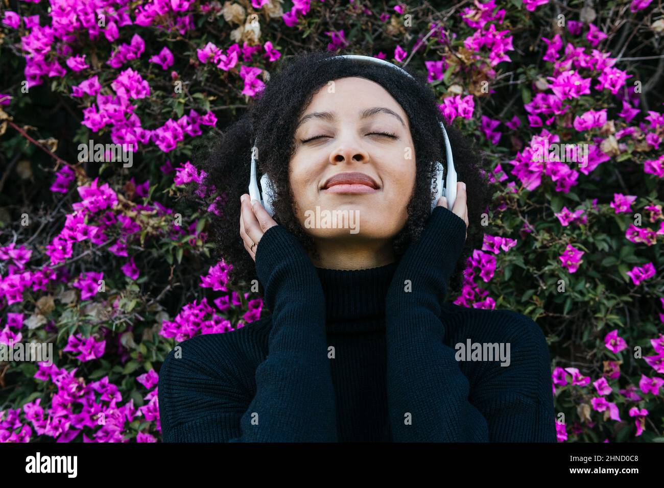 Content African American female in black wear listening to music in ...