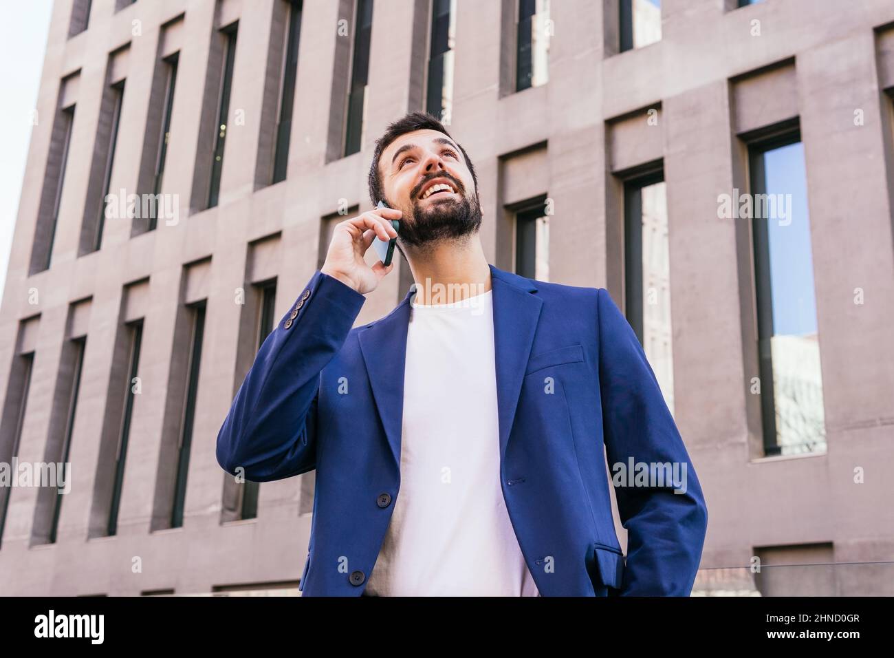 From below content bearded male entrepreneur in formal wear looking up ...