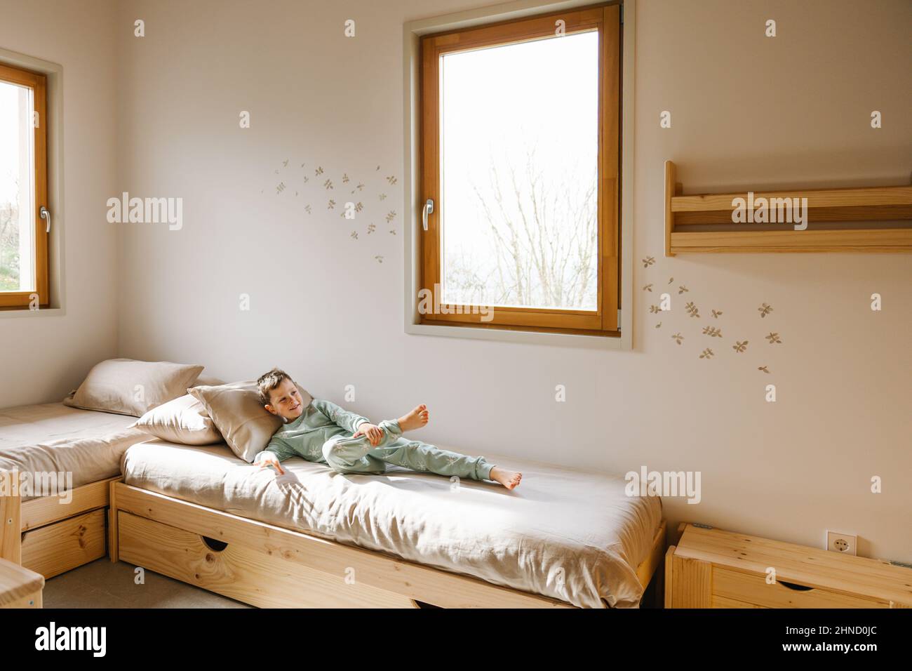 Full Body Of Positive Barefoot Boy In Pajama Looking Away While Lying 0309