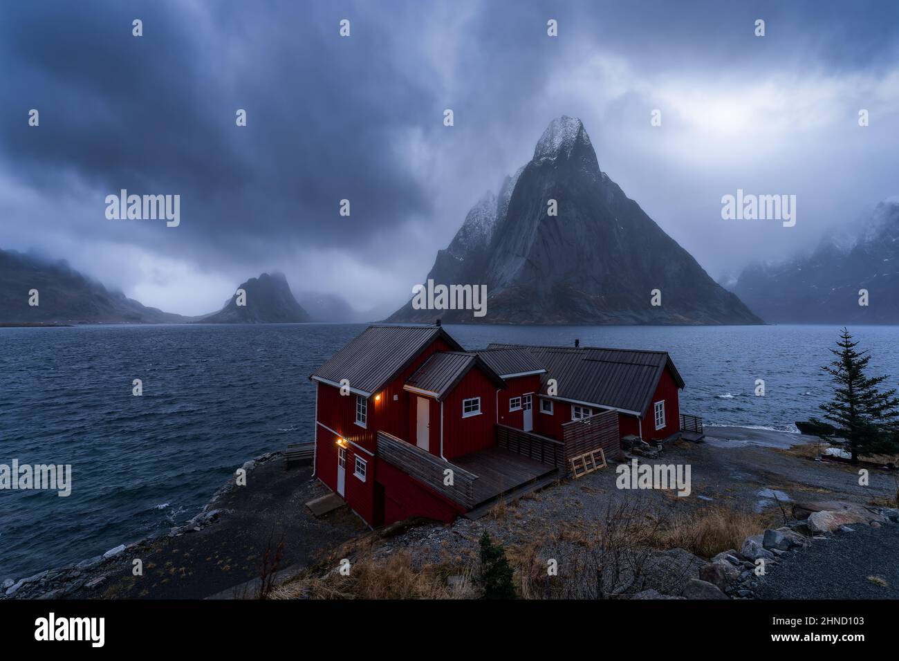 Breathtaking view of seacoast near rough rocky cliff with small red ...