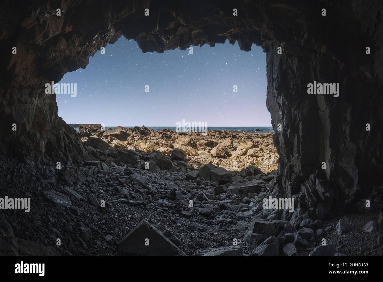 Majestic landscape of cave and rocky coast near sea under sky with ...