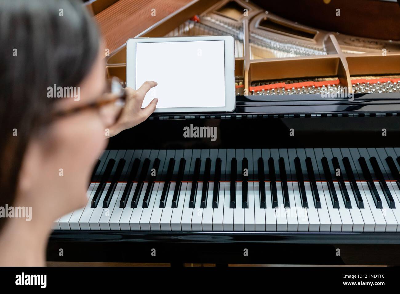 Unrecognizable blurred female musician touching tablet with blank ...