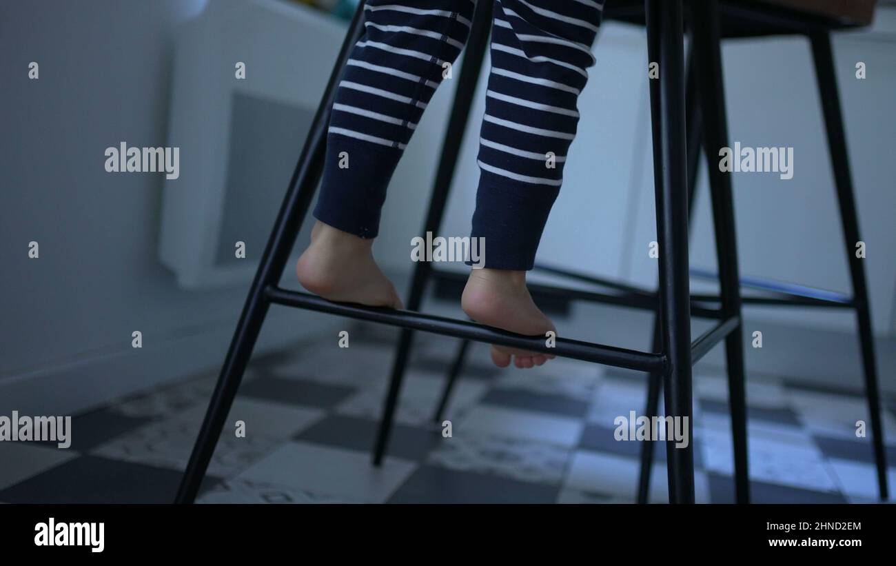 Child climbing down from high-chair little boy getting down from stool ...