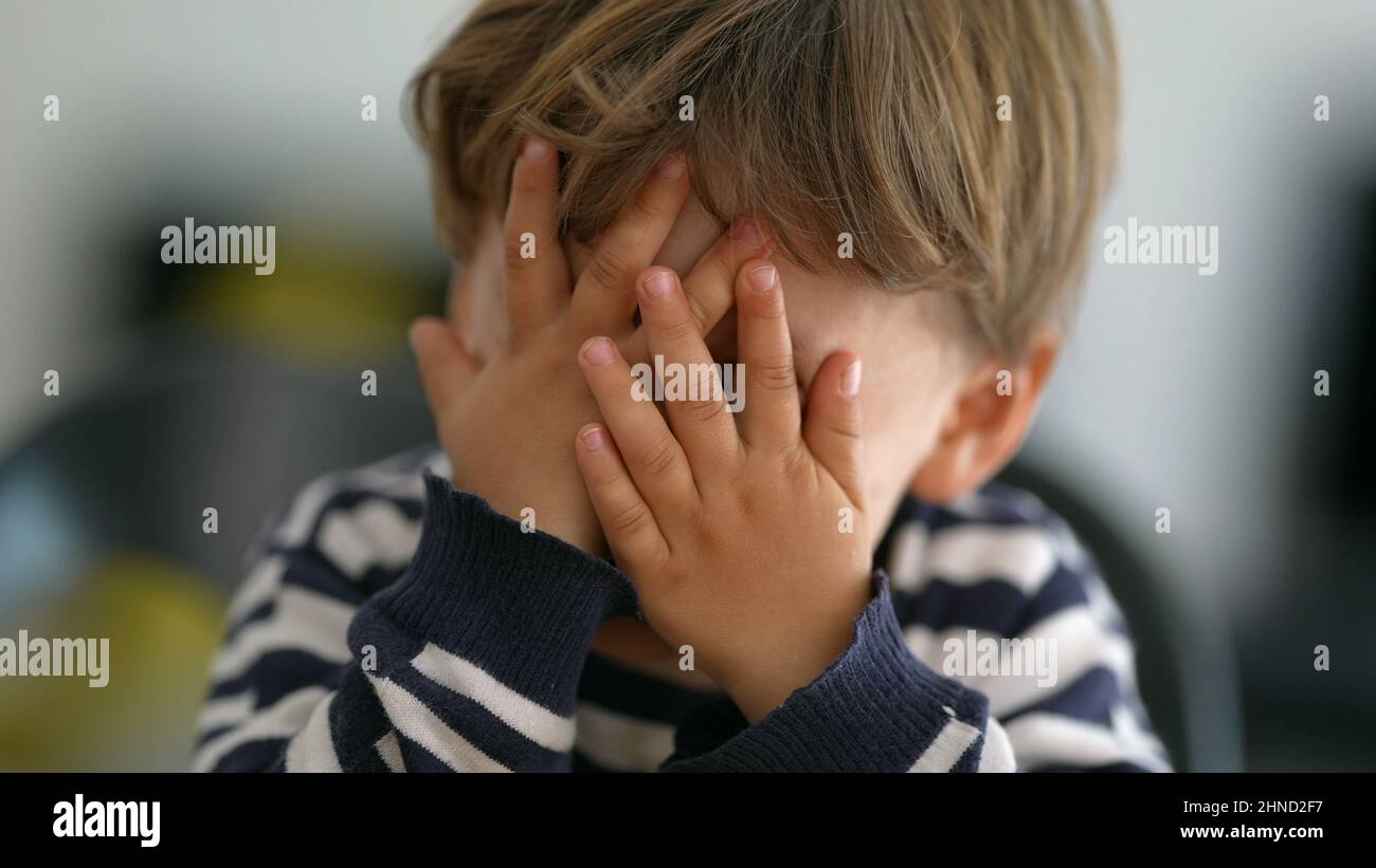 Child covering face with hands OH no Stock Photo - Alamy