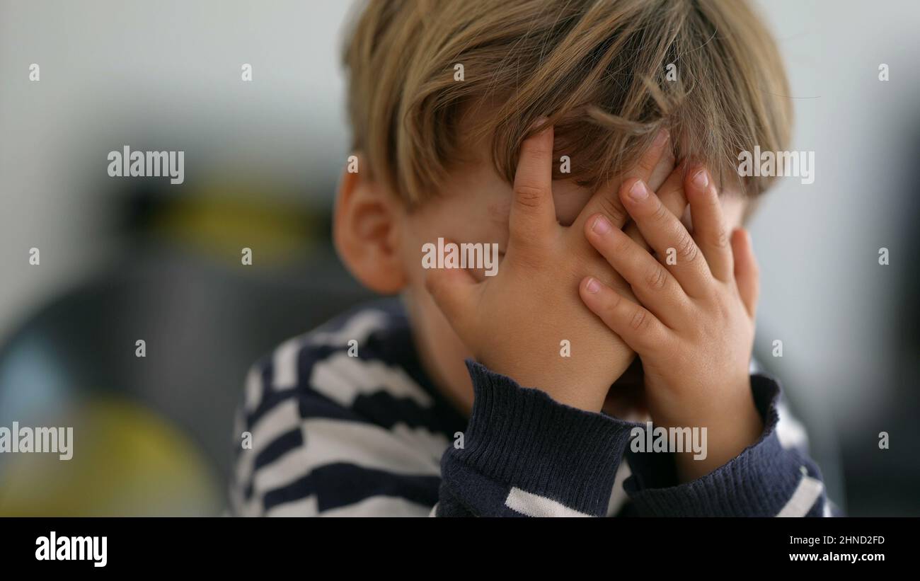Child covering face with hands OH no Stock Photo - Alamy