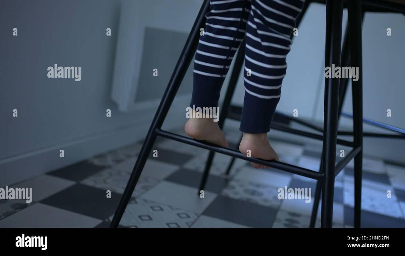 Child climbing down from high-chair little boy getting down from stool ...