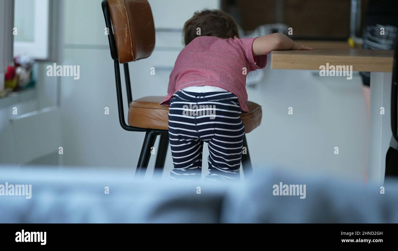 Child getting down from chair candid little boy steps down from high ...