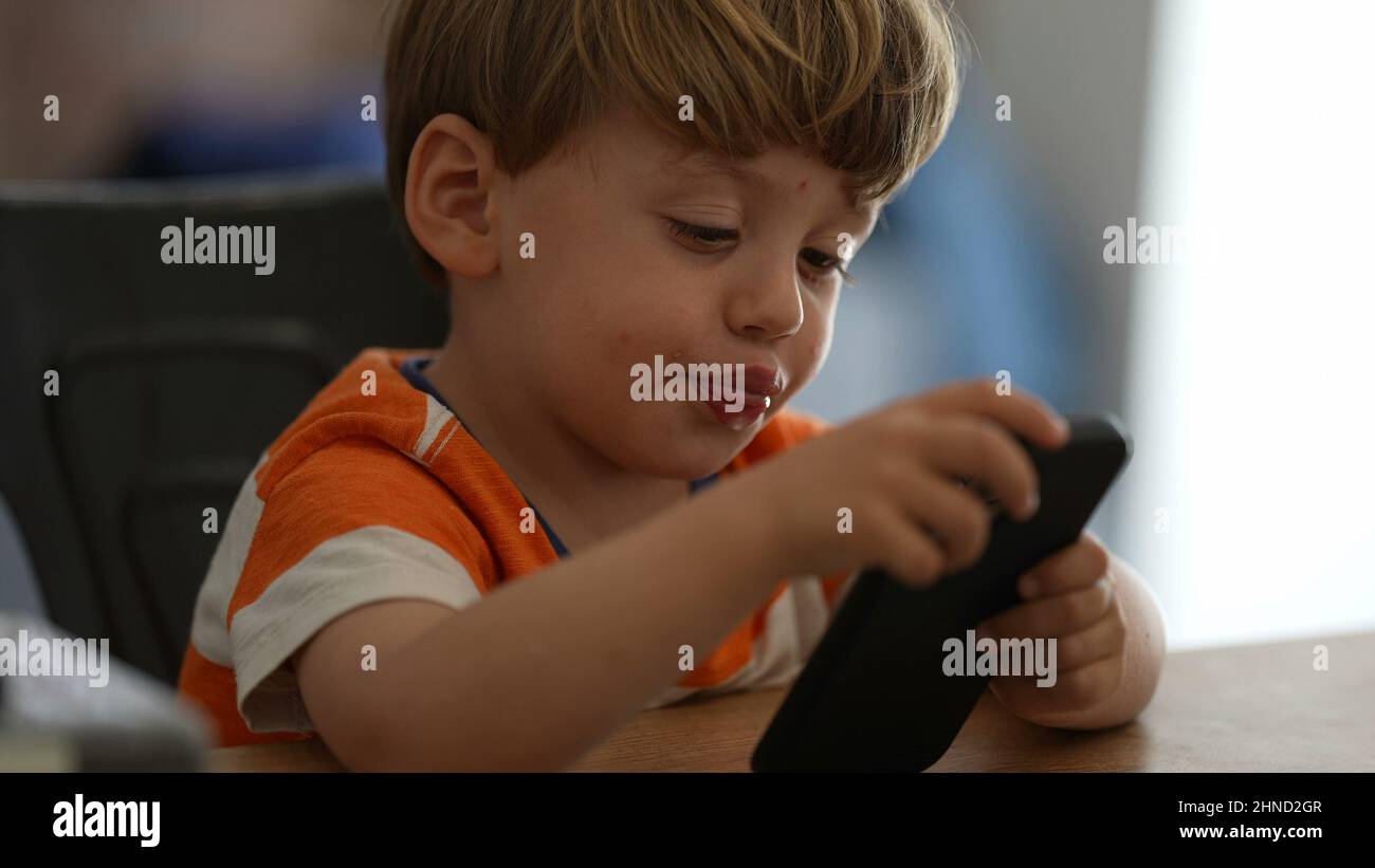 Child holding phone using technology Stock Photo - Alamy