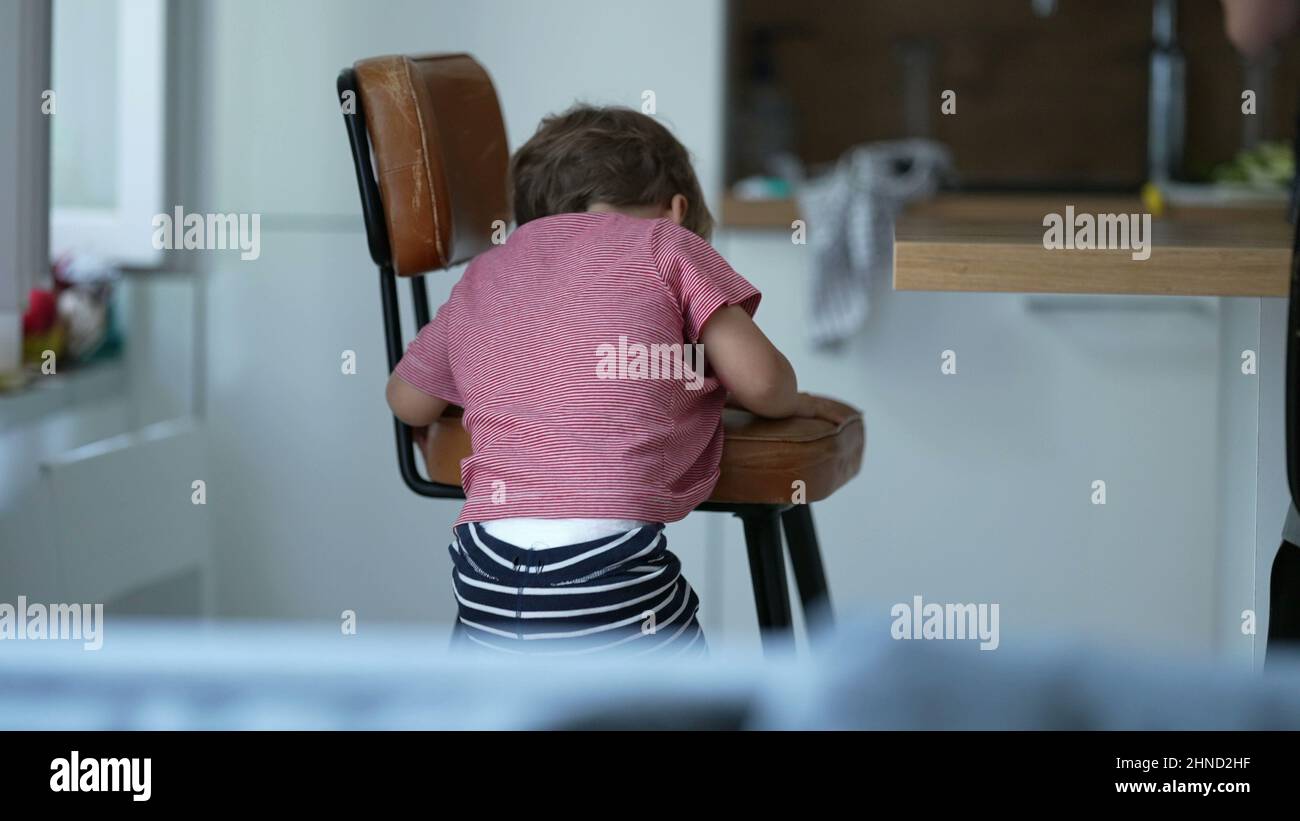 Child getting down from chair candid little boy steps down from high ...