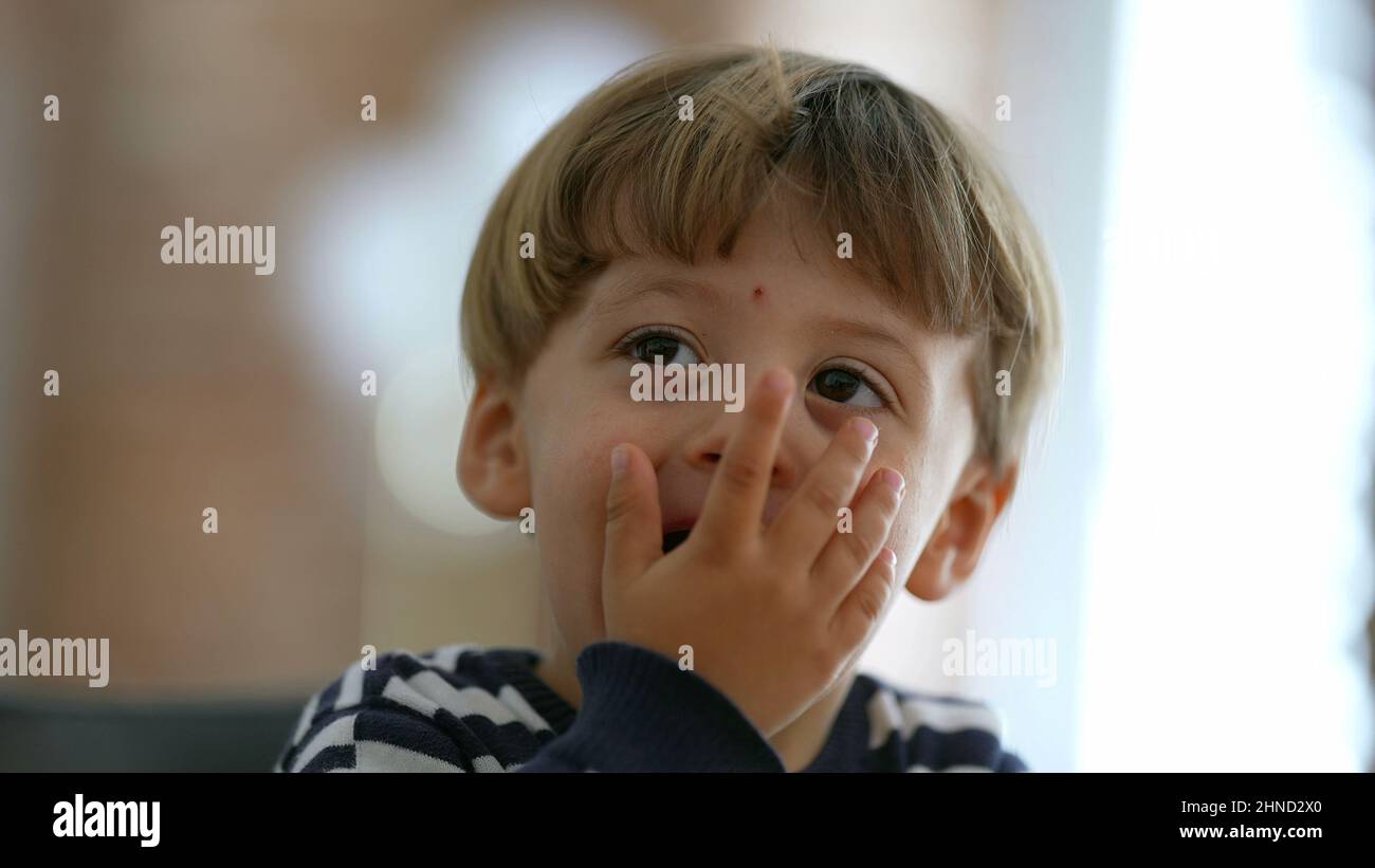 Child reaction with unbelief covering mouth with hand in disbelief ...