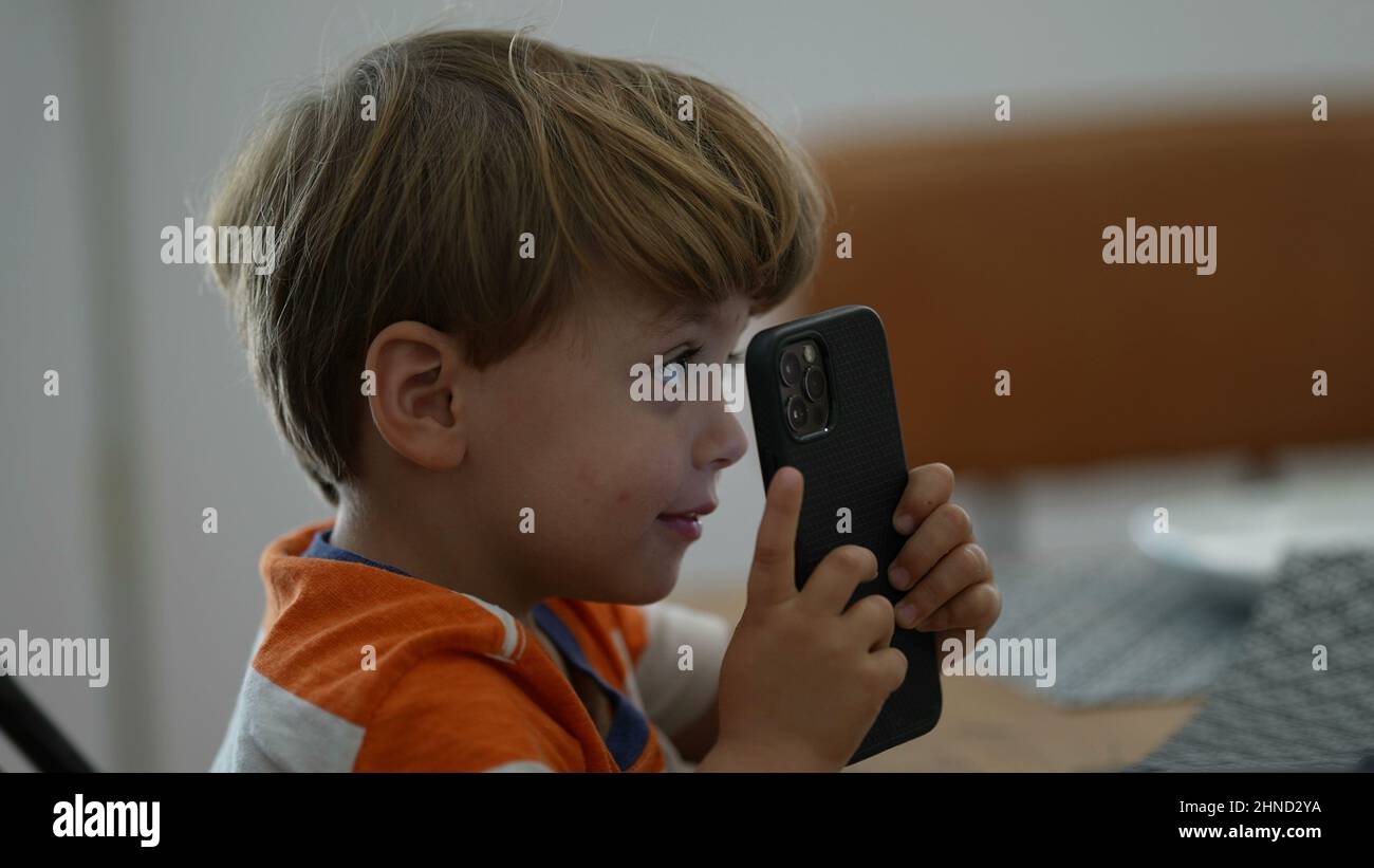 Child taking photo with phone kid holding smartphone takes picture ...