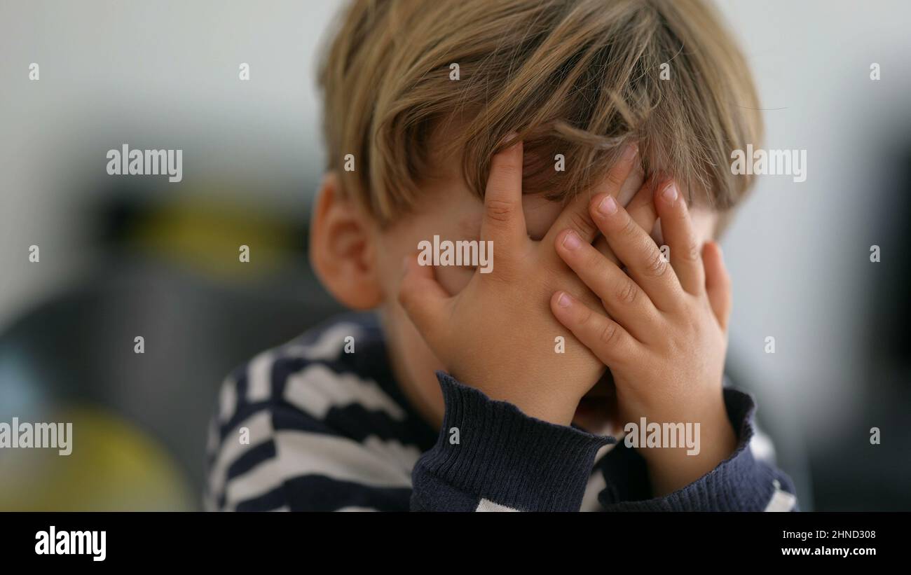 Child uncovering face with hand playing peekaboo Stock Photo - Alamy