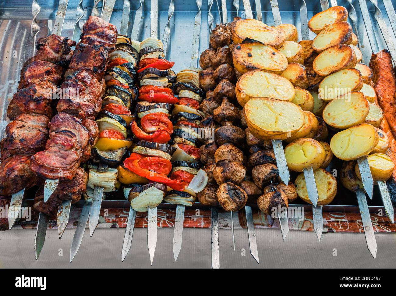 Cooking shashlik on a metal skewer and grilled vegetables. Grilled meat ...