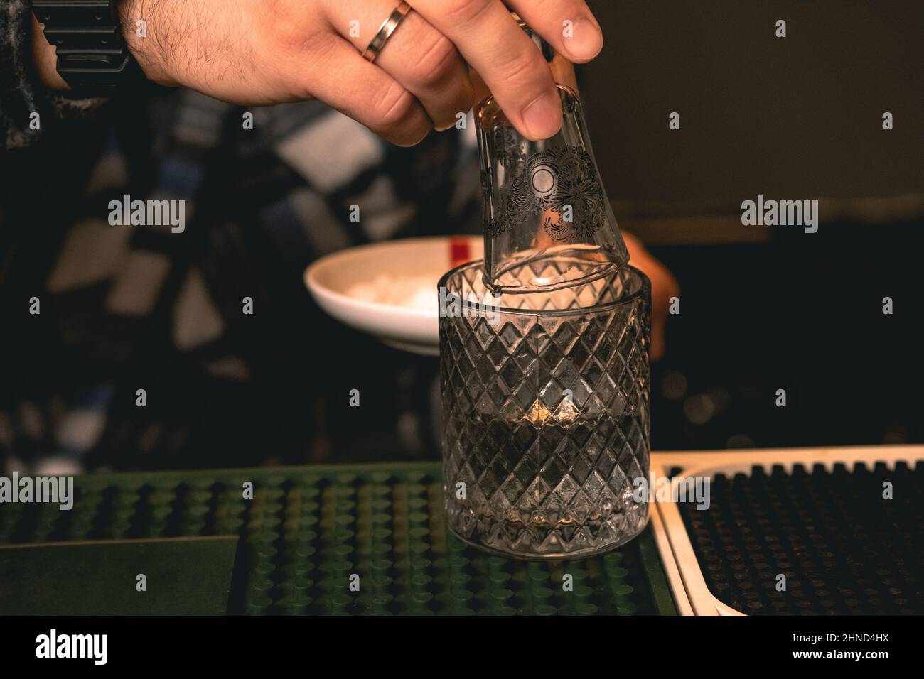 Man dipping glass into water before dipping in salt for serving tequila ...
