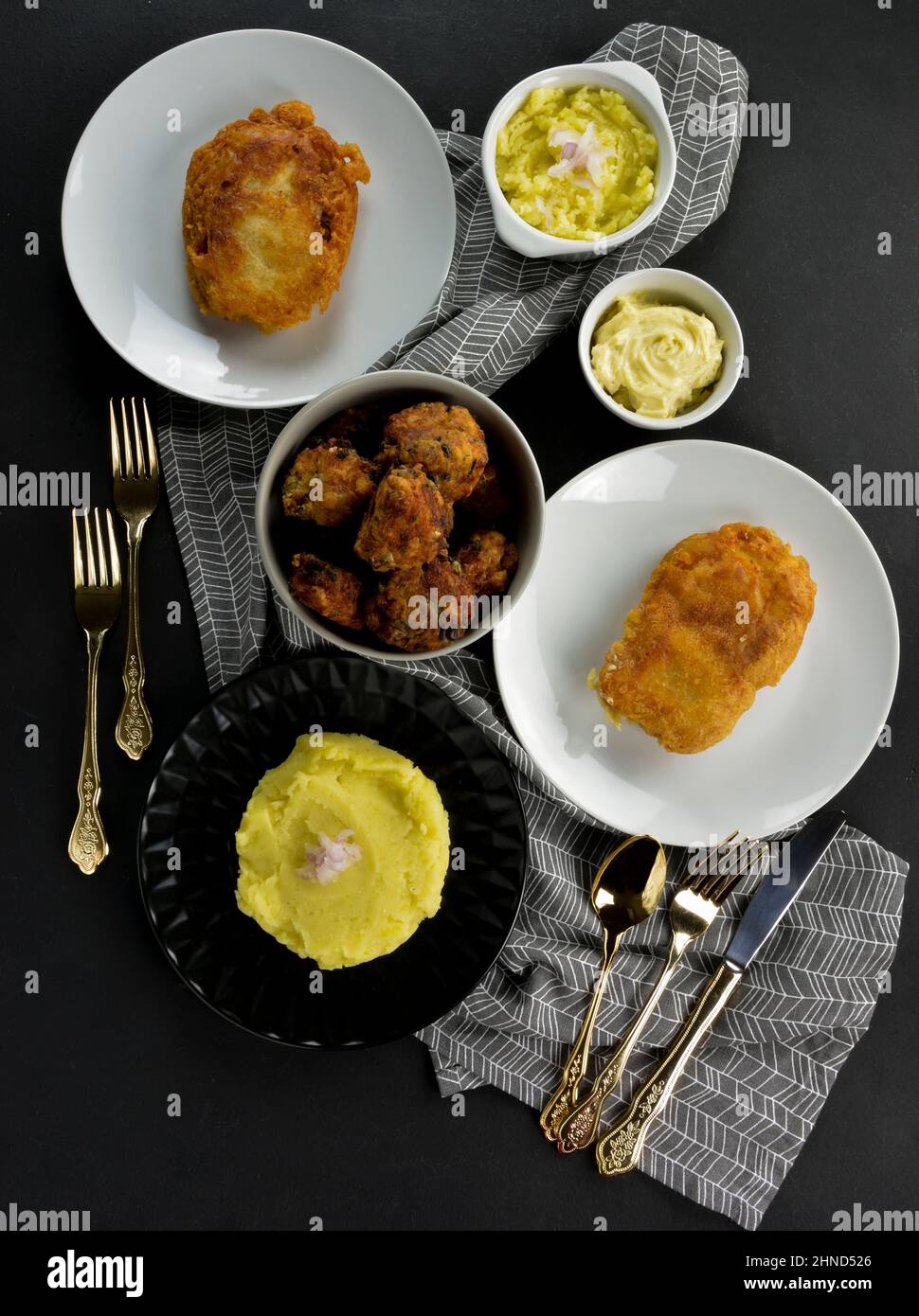 Two fillets of fried cod fish, bowl with croquettes of cod fish ...