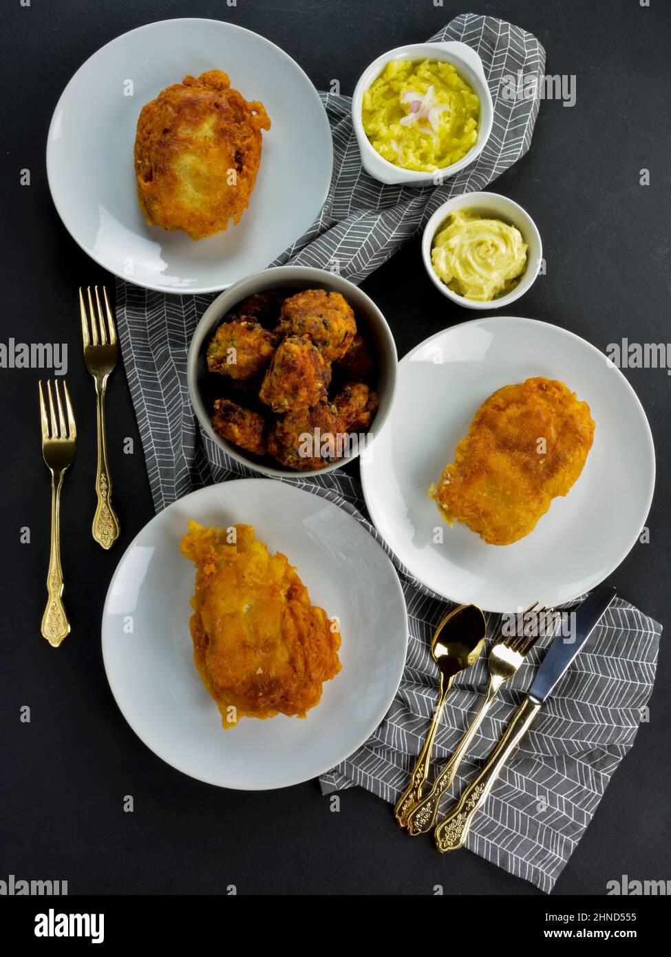 Fillets of fried cod fish in plates, bowl with croquettes of cod fish ...
