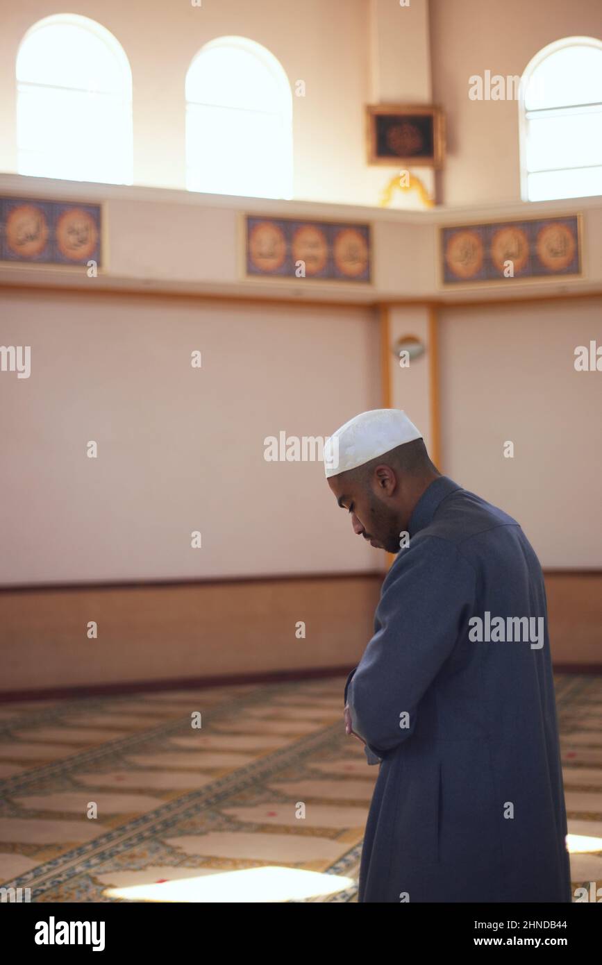 A young Muslim man standing during prayers at a mosque Stock Photo - Alamy