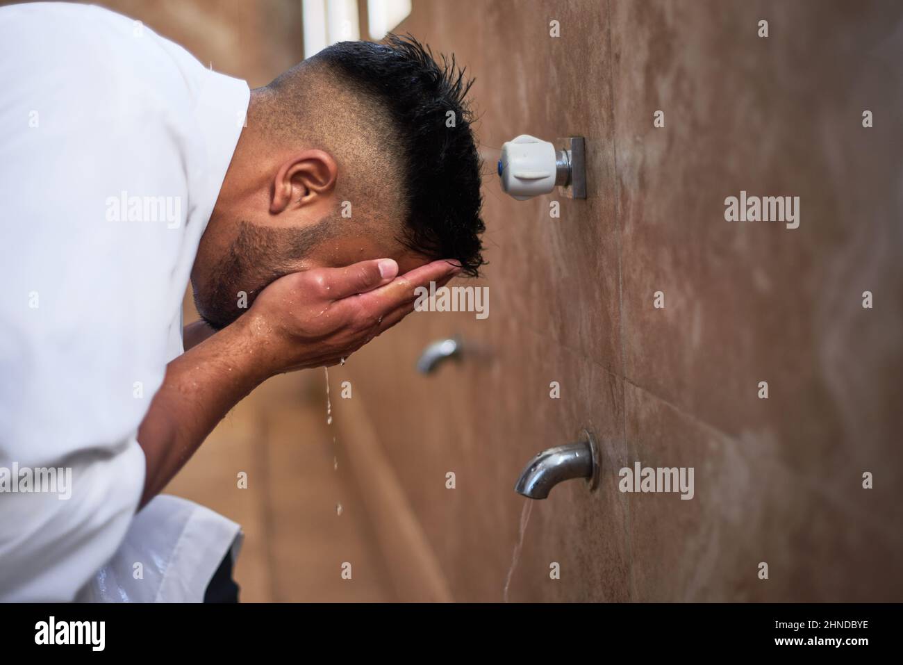 A young Muslim man cleansing his face in the mosque Stock Photo - Alamy
