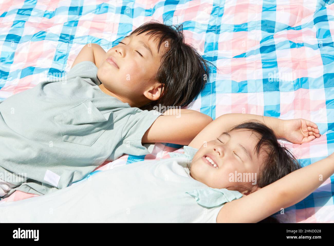 Japanese Brother And Sister Lying Down Stock Photo - Alamy