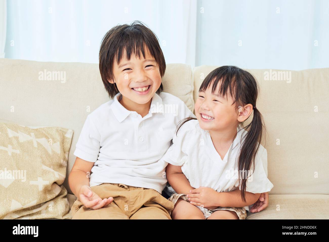 Japanese Brother And Sister Relaxing On The Sofa Stock Photo - Alamy