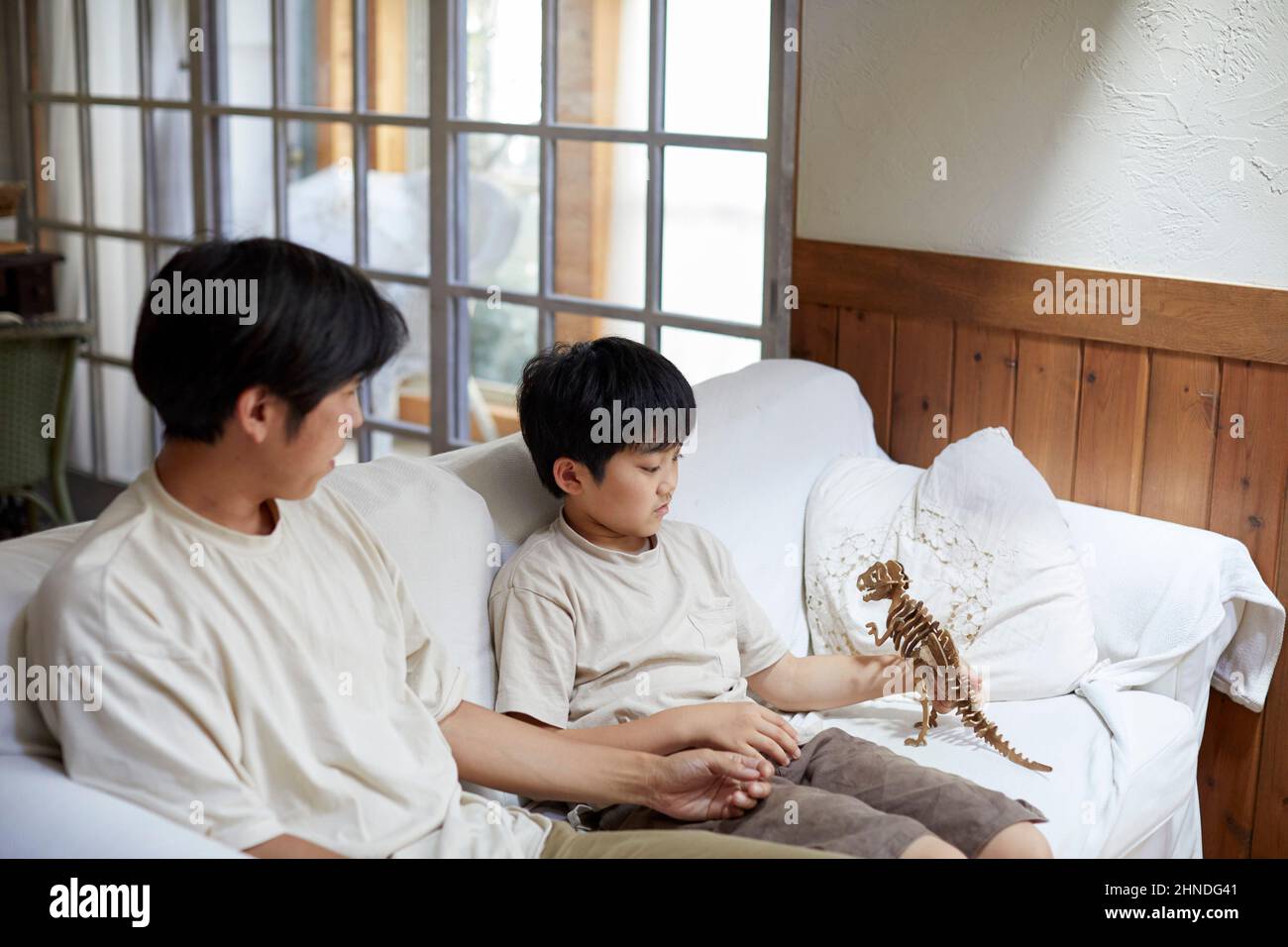 Japanese Parent And Child Sitting On The Sofa Stock Photo - Alamy