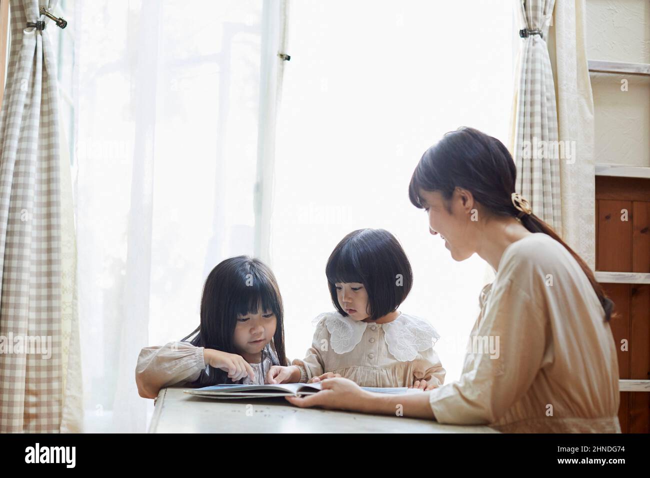 Japanese Parent And Child Reading A Book Stock Photo - Alamy