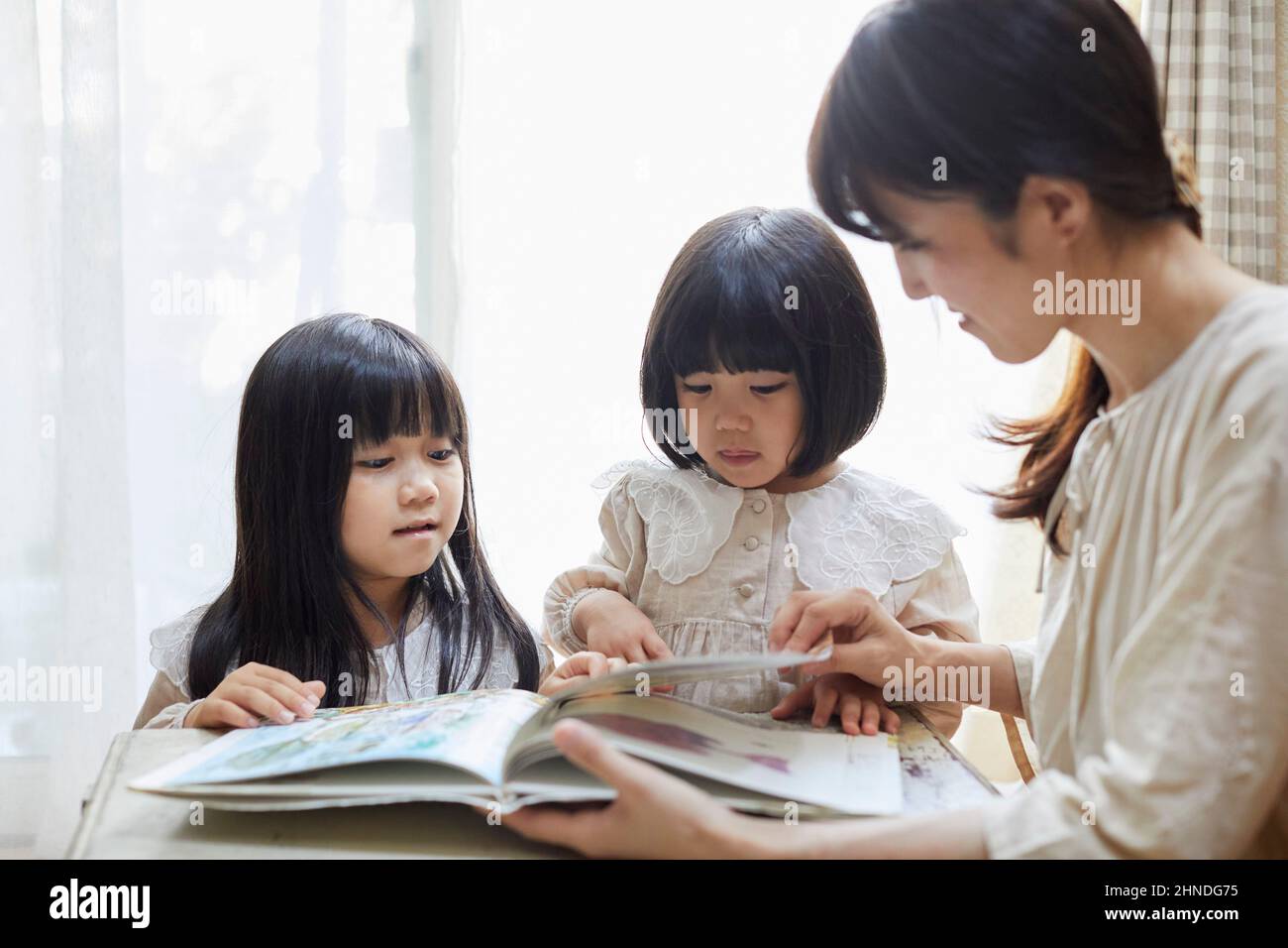 Japanese Parent And Child Reading A Book Stock Photo - Alamy