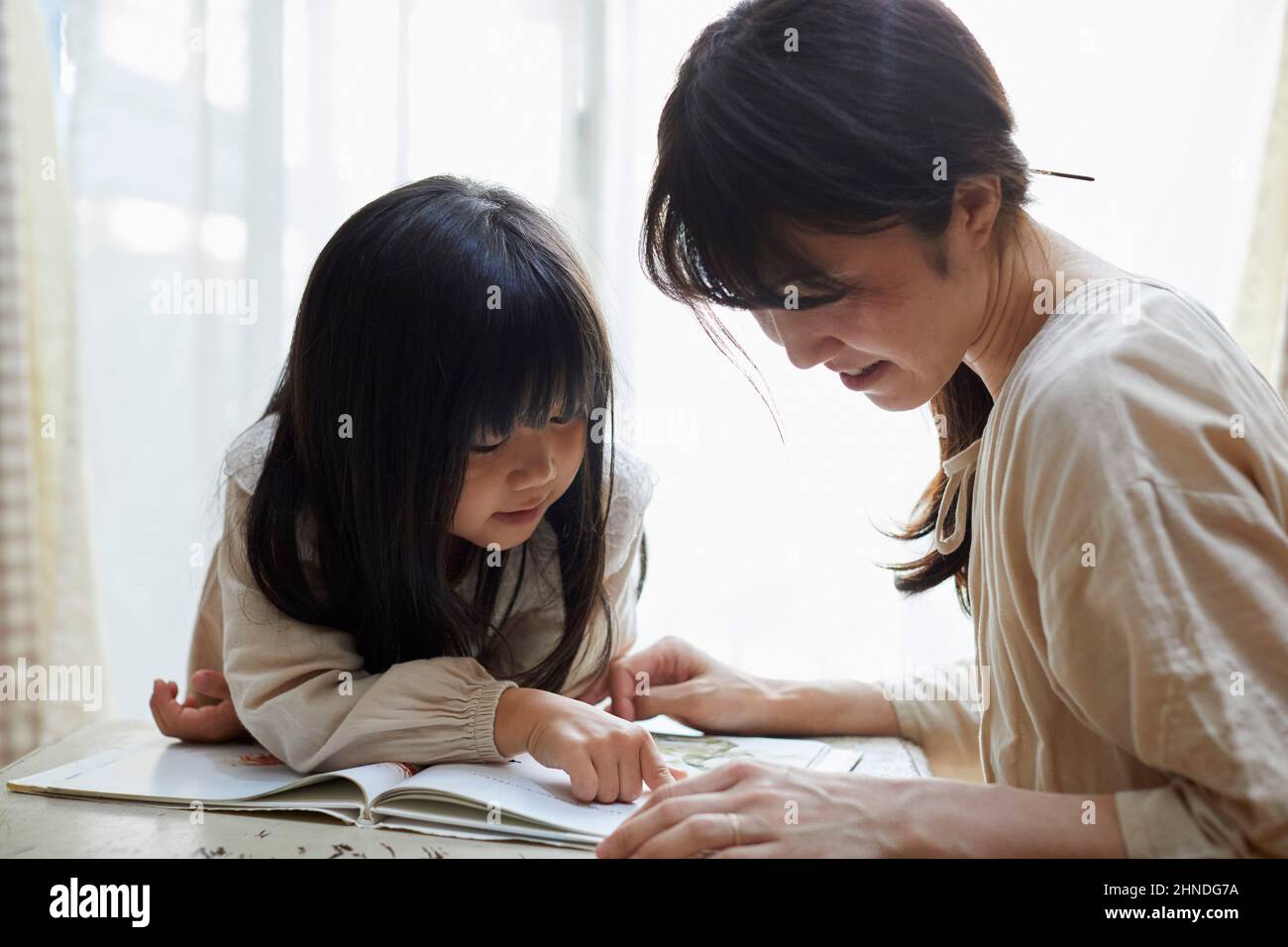 Japanese Parent And Child Reading A Book Stock Photo - Alamy