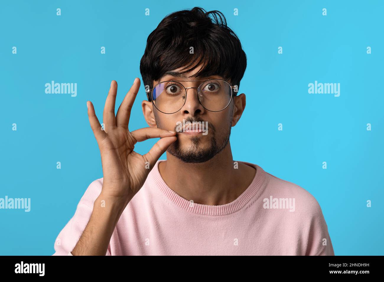 Handsome young middle eastern guy showing mouth zipped gesture Stock ...
