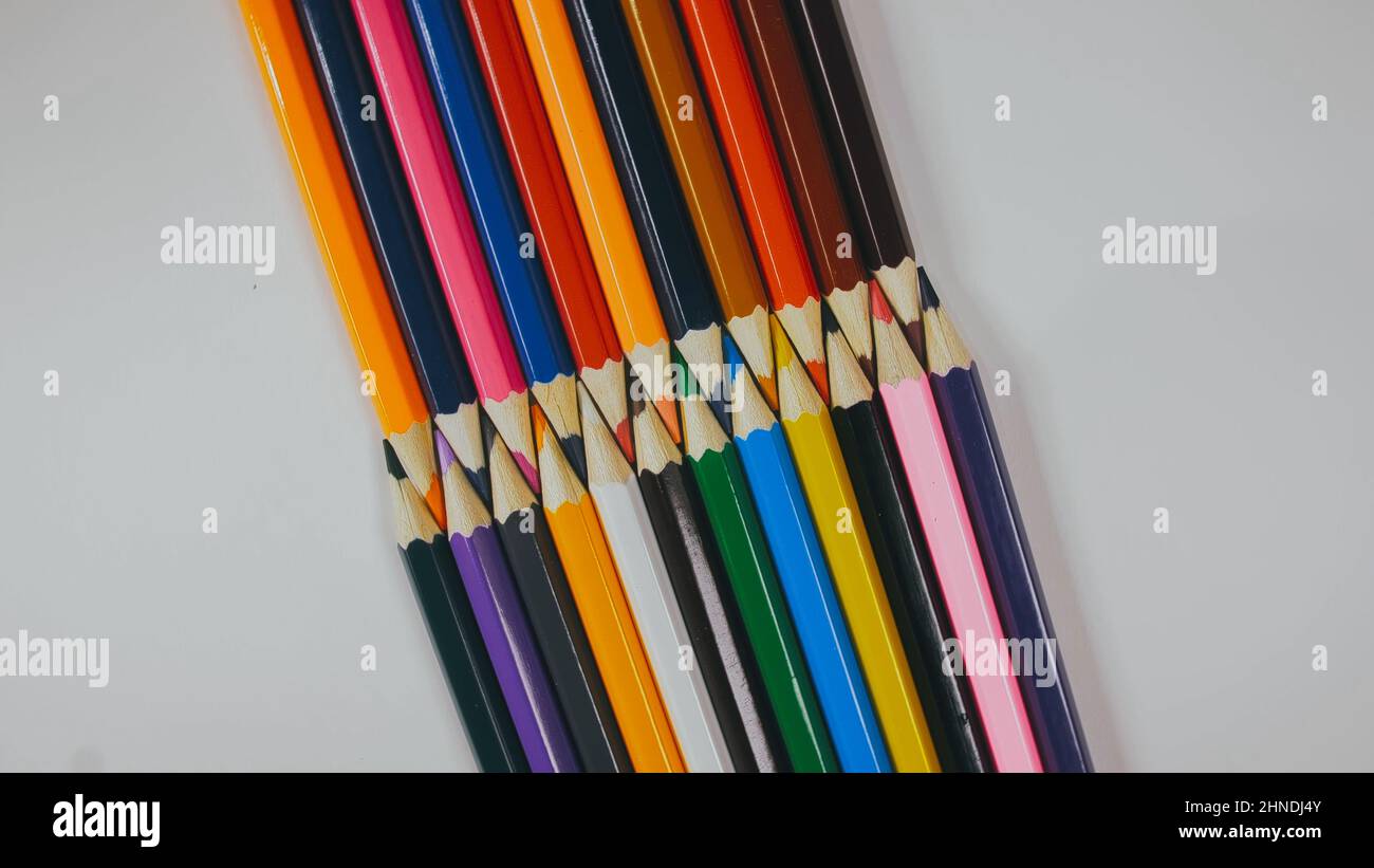 Many colored pencils are arranged around the edges of the image as a ...