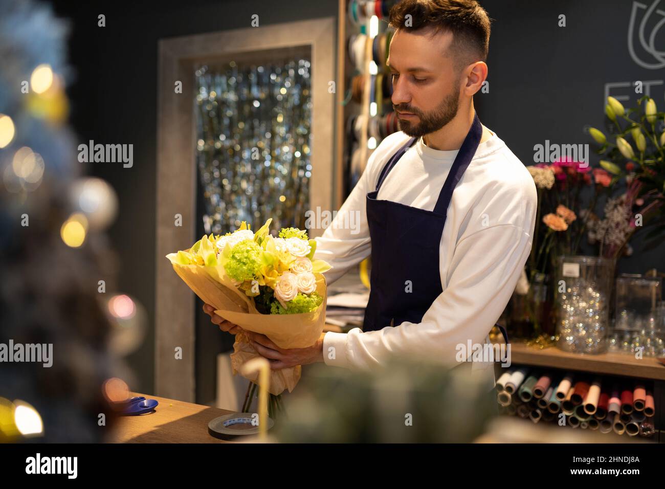an employee of a floristic shop with a bouquet in his hands against the ...