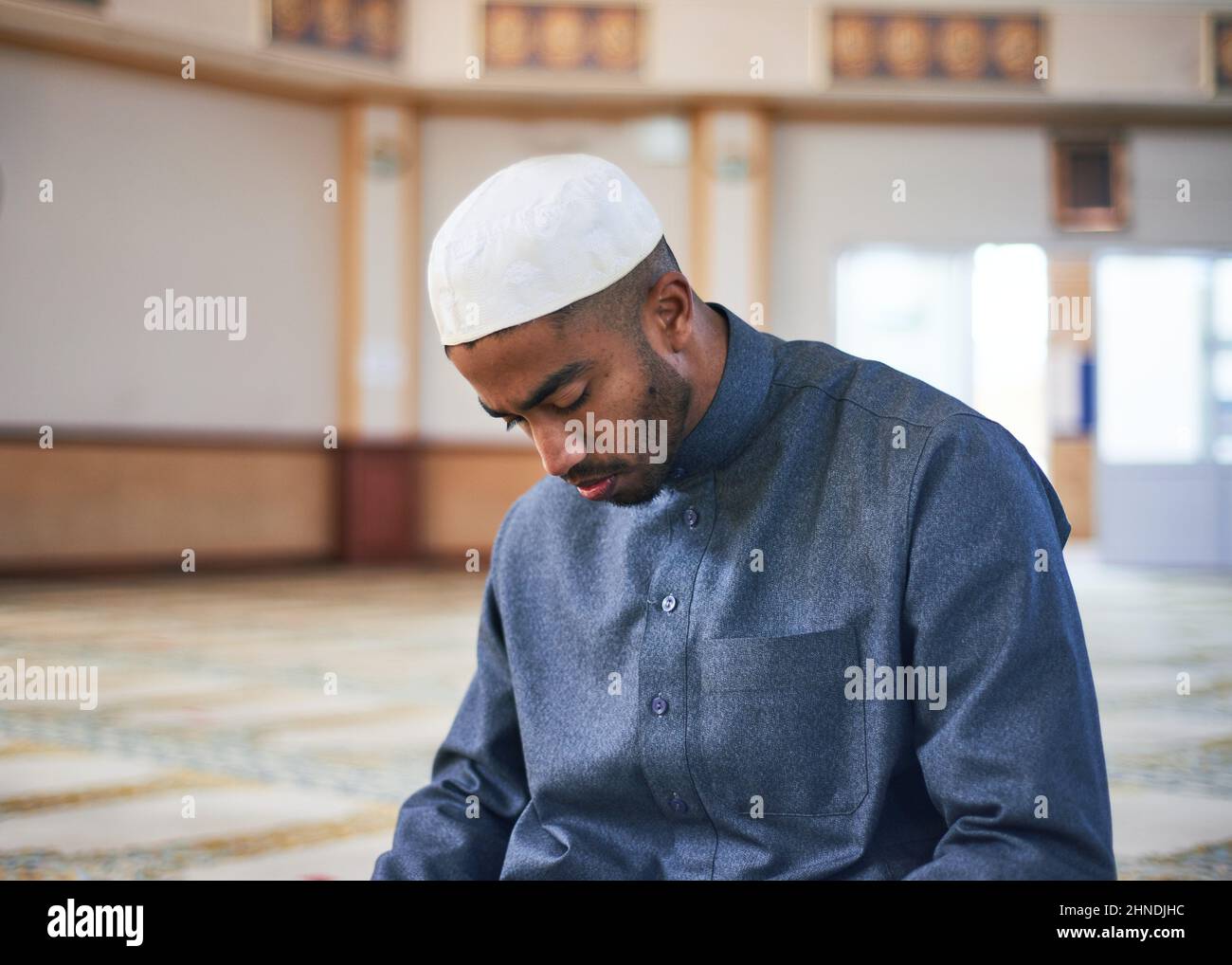 A Muslim man bows his head in prayer while kneeling in a mosque Stock ...