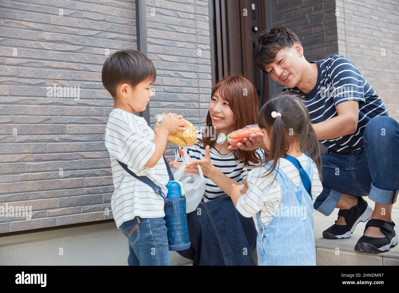 Japanese Boy Handing Over The Items He Bought To His Parents Stock ...