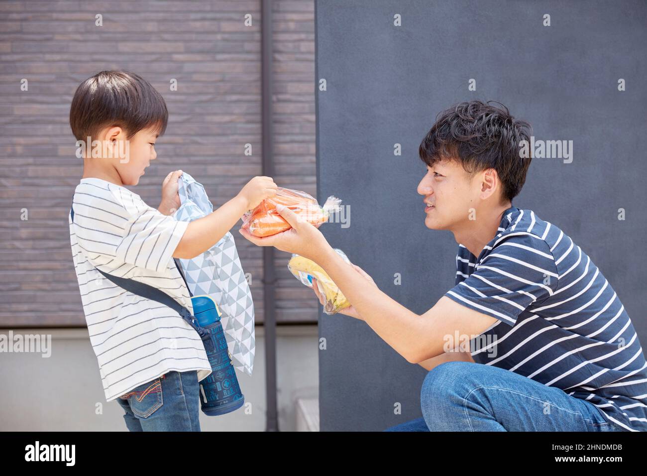 Japanese Boy Handing Something He Bought To His Parents Stock Photo - Alamy