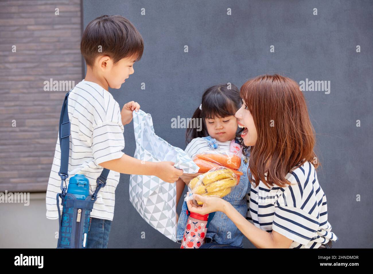 Japanese Boy Handing Something He Bought To His Parents Stock Photo - Alamy