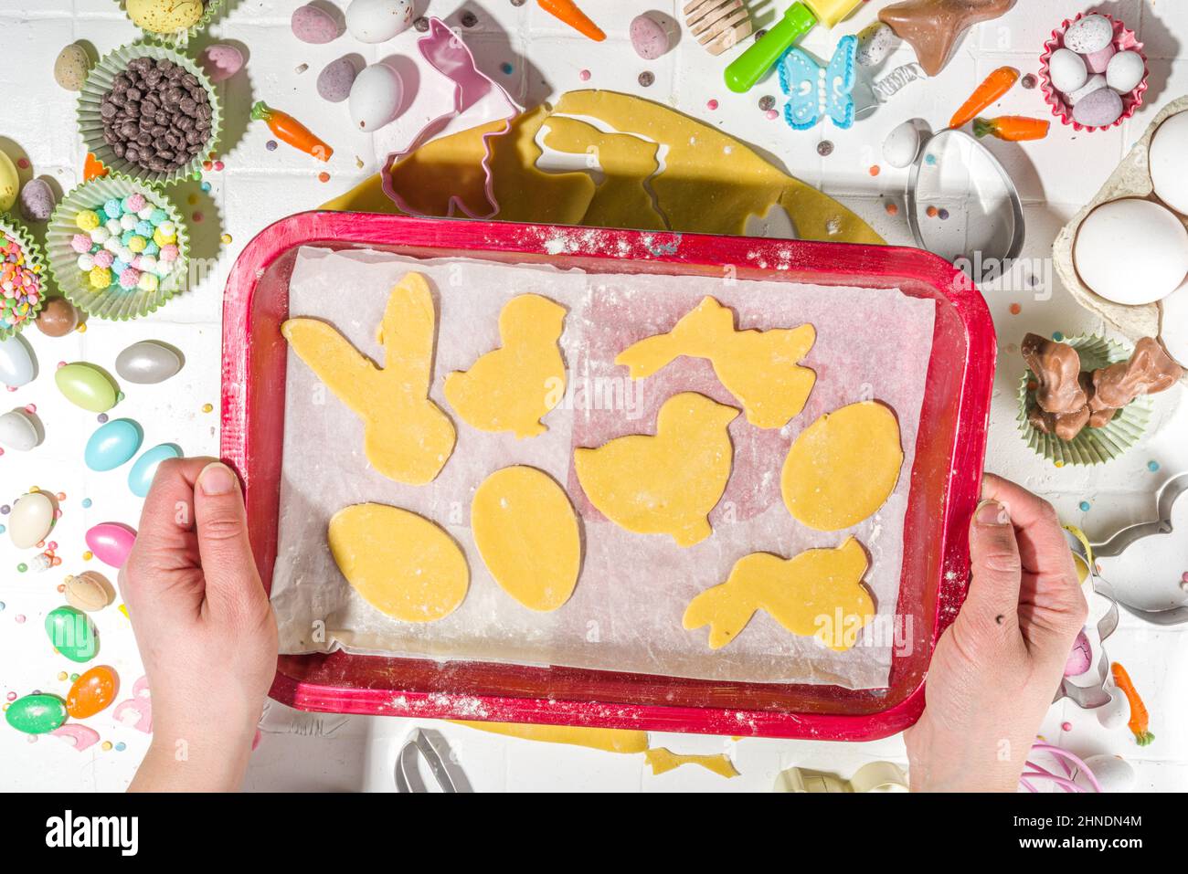 Woman hands kneading dough on table and cooking Easter sugar cookies ...