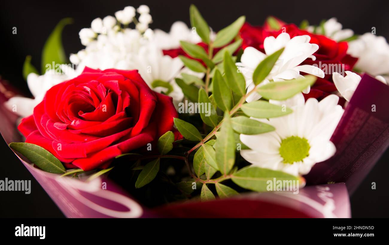 Closeup bouquet of red roses with with daisies Stock Photo - Alamy